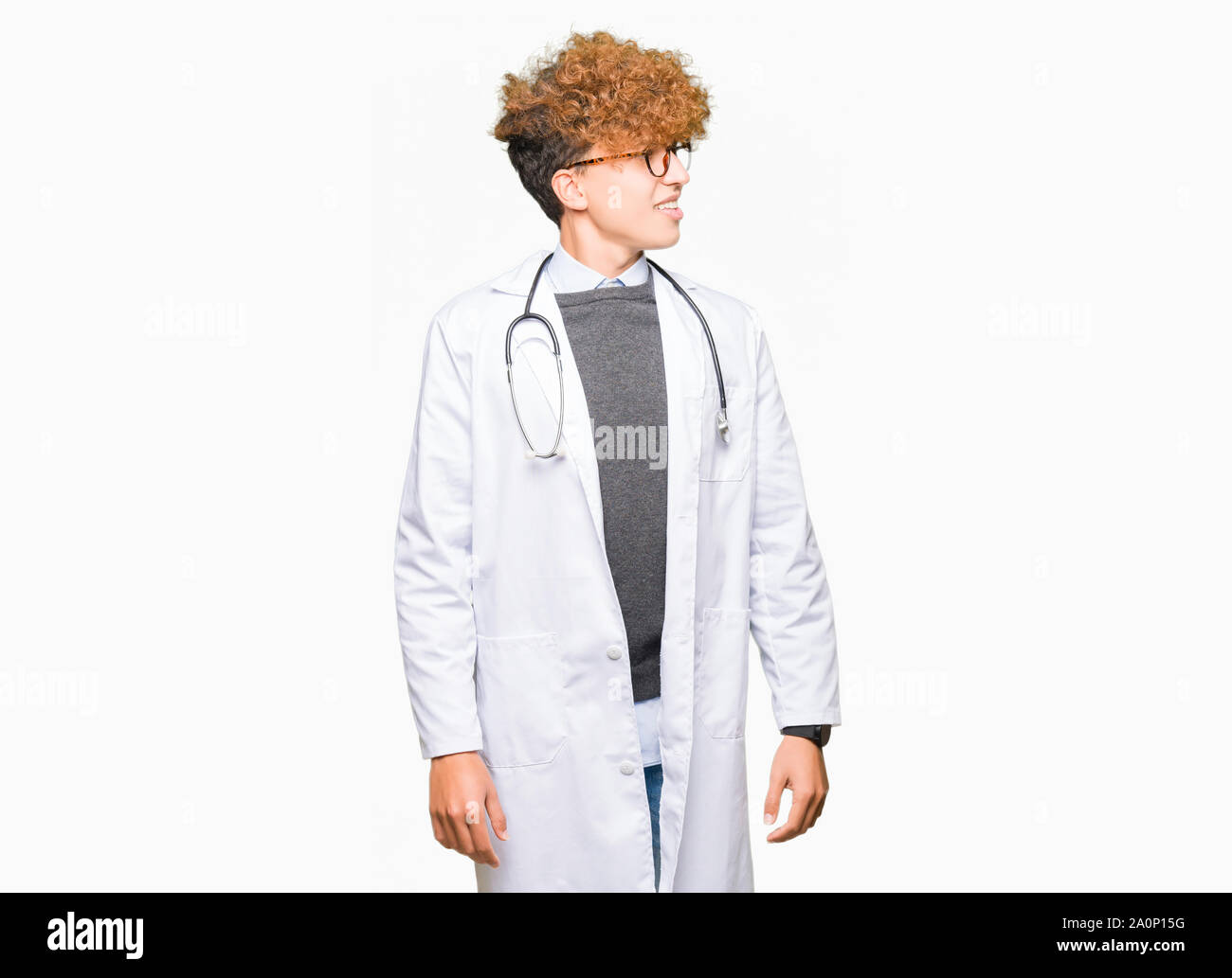 Young handsome doctor man wearing medical coat looking away to side ...