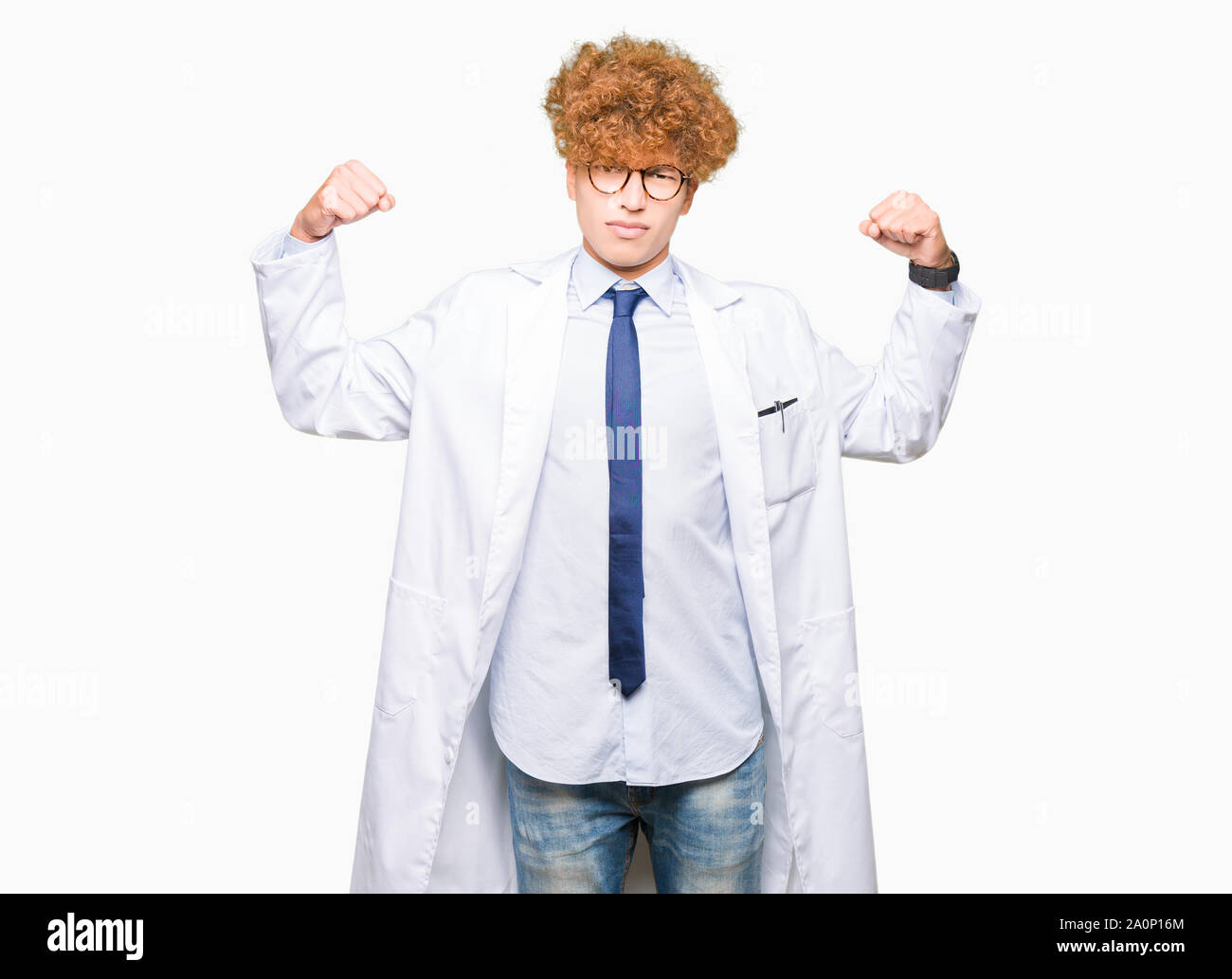 Young handsome scientist man wearing glasses showing arms muscles ...