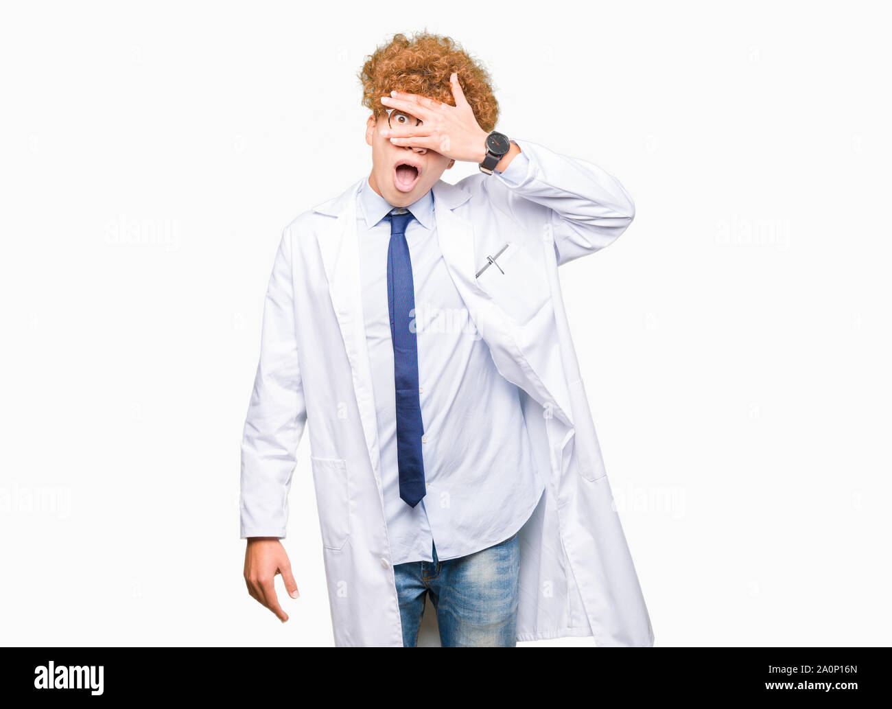 Young handsome scientist man wearing glasses peeking in shock covering ...