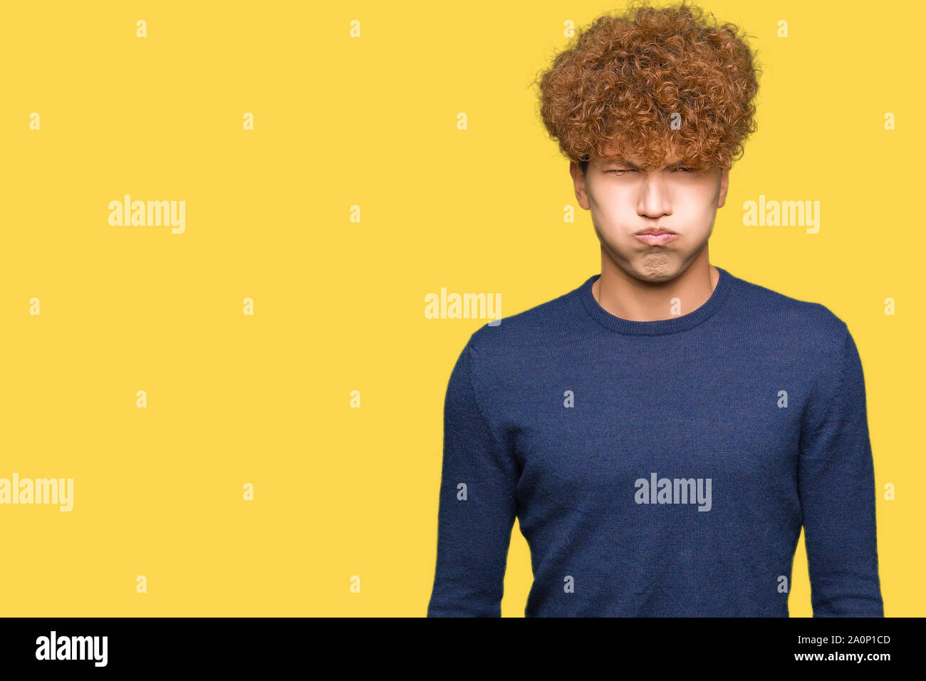 Young handsome man with afro hair puffing cheeks with funny face. Mouth ...
