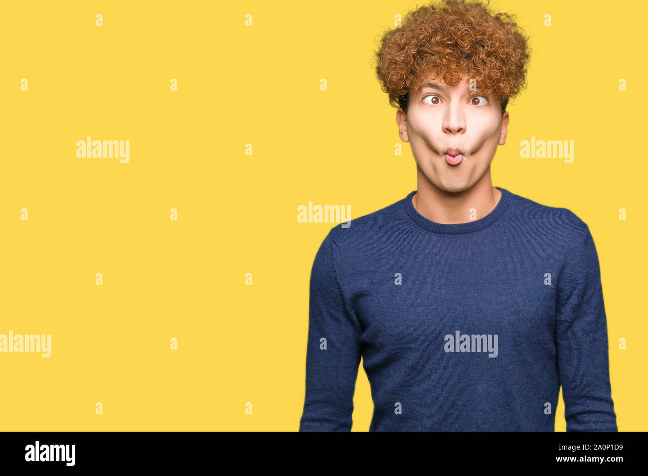 Young handsome man with afro hair making fish face with lips, crazy and ...