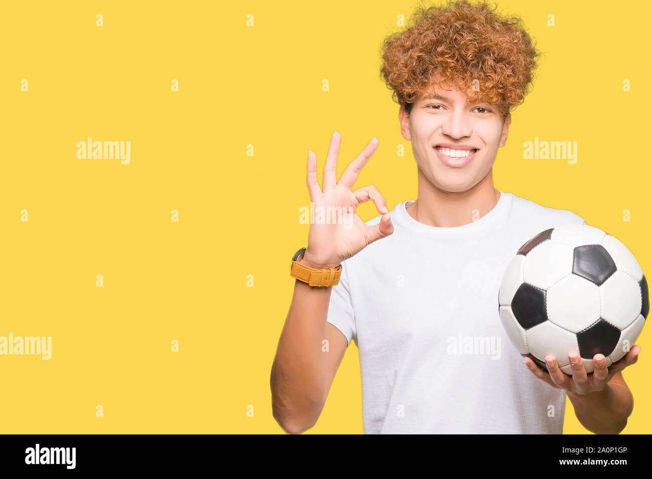 Young handsome man holding soccer football ball doing ok sign with ...
