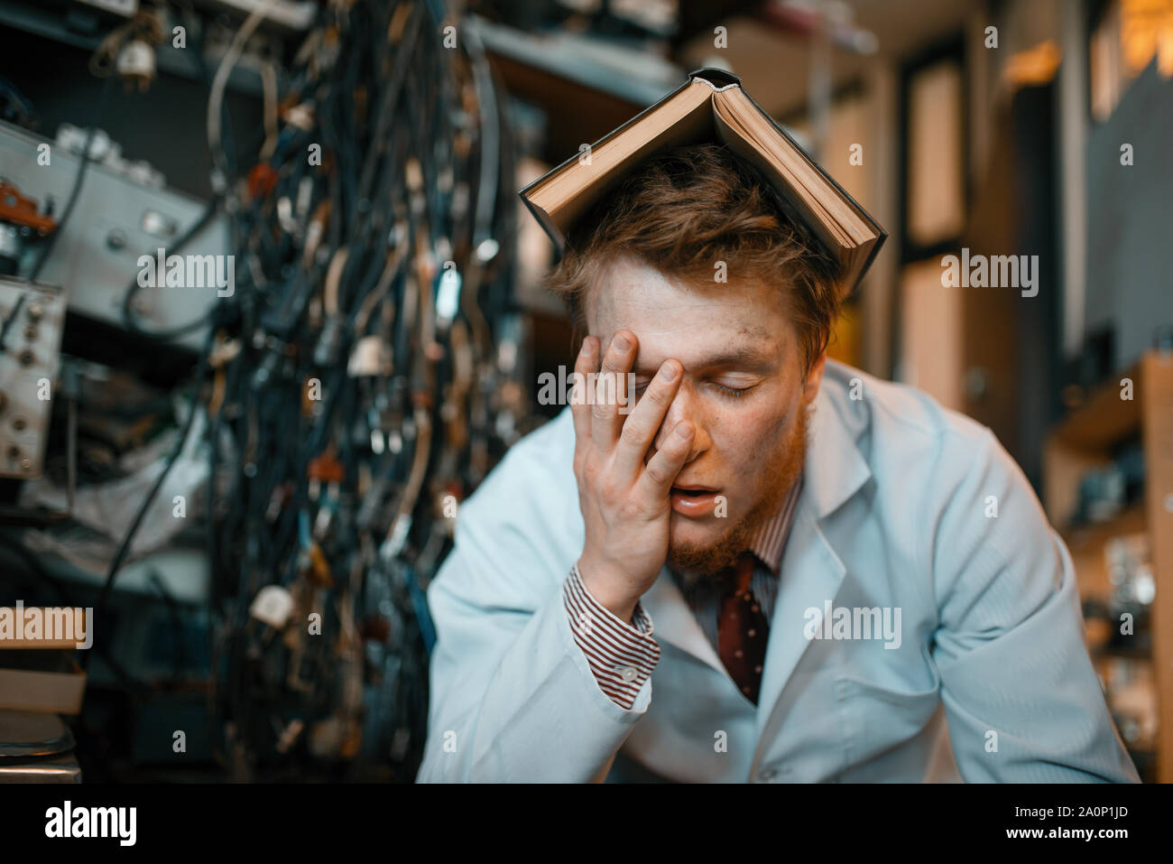 Tired strange engineer with book on his head Stock Photo - Alamy