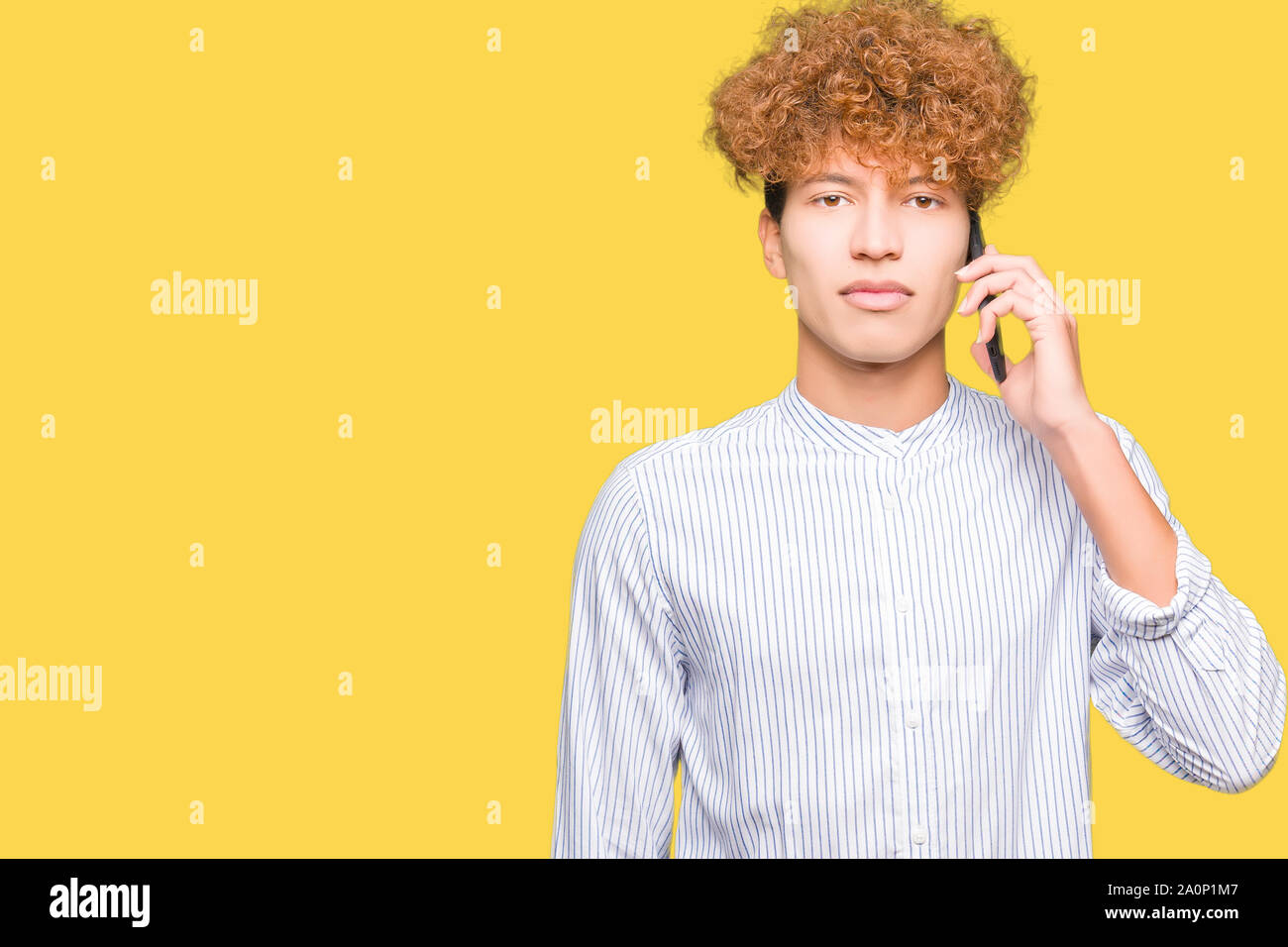 Young handsome man talking on the phone with a confident expression on ...