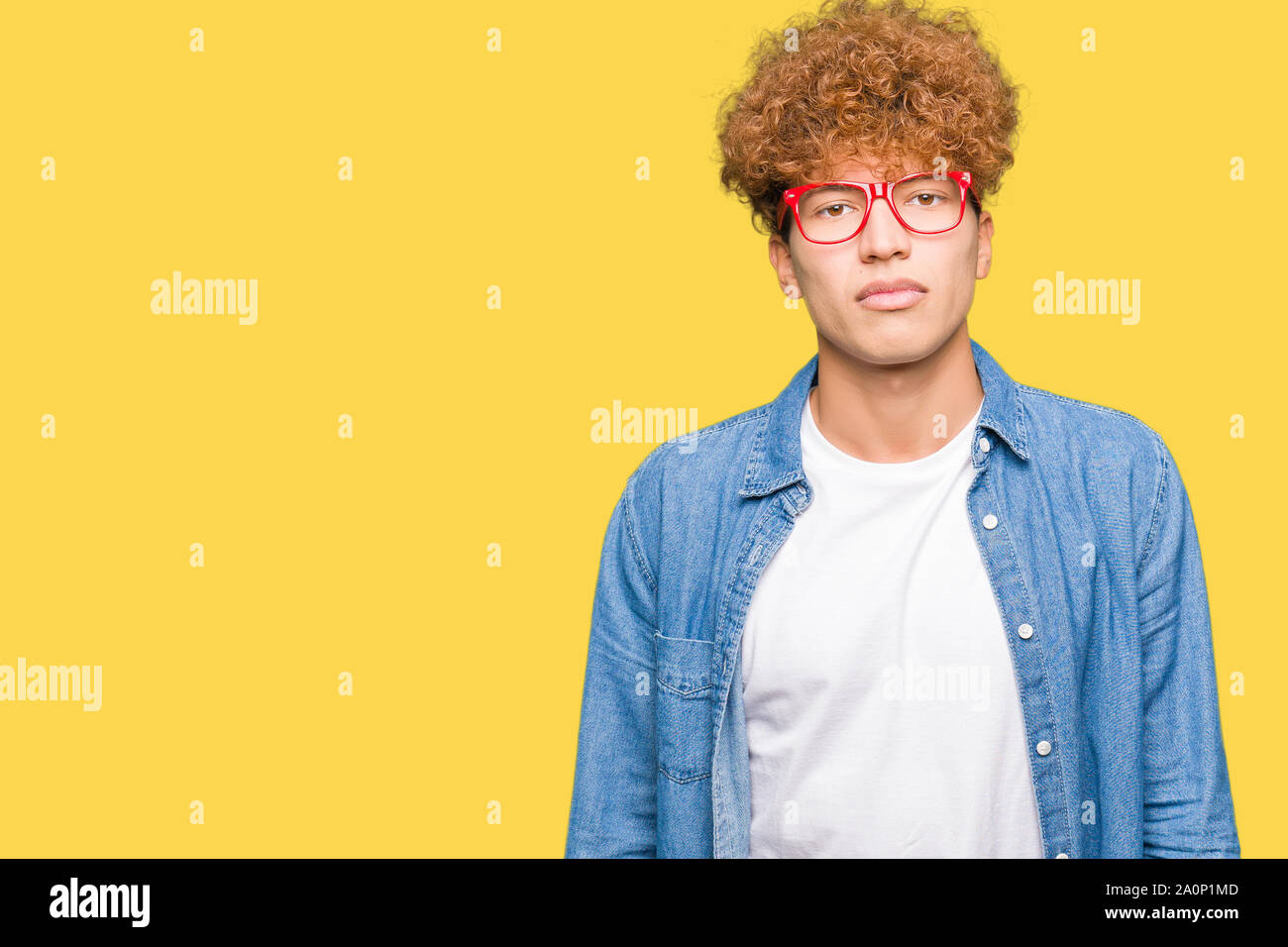 Young handsome man with afro hair wearing glasses with serious ...