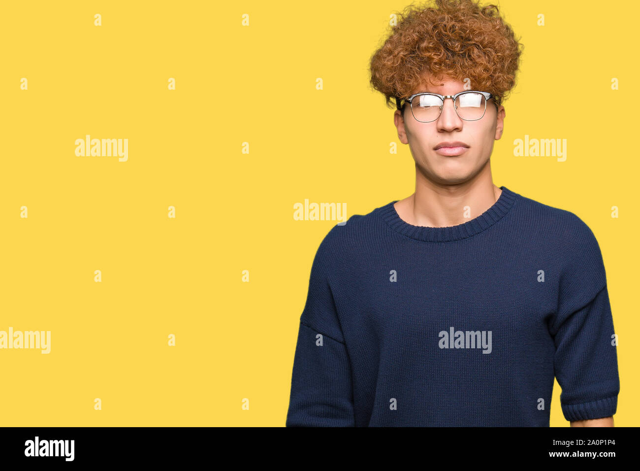 Young handsome man with afro wearing glasses with serious expression on ...