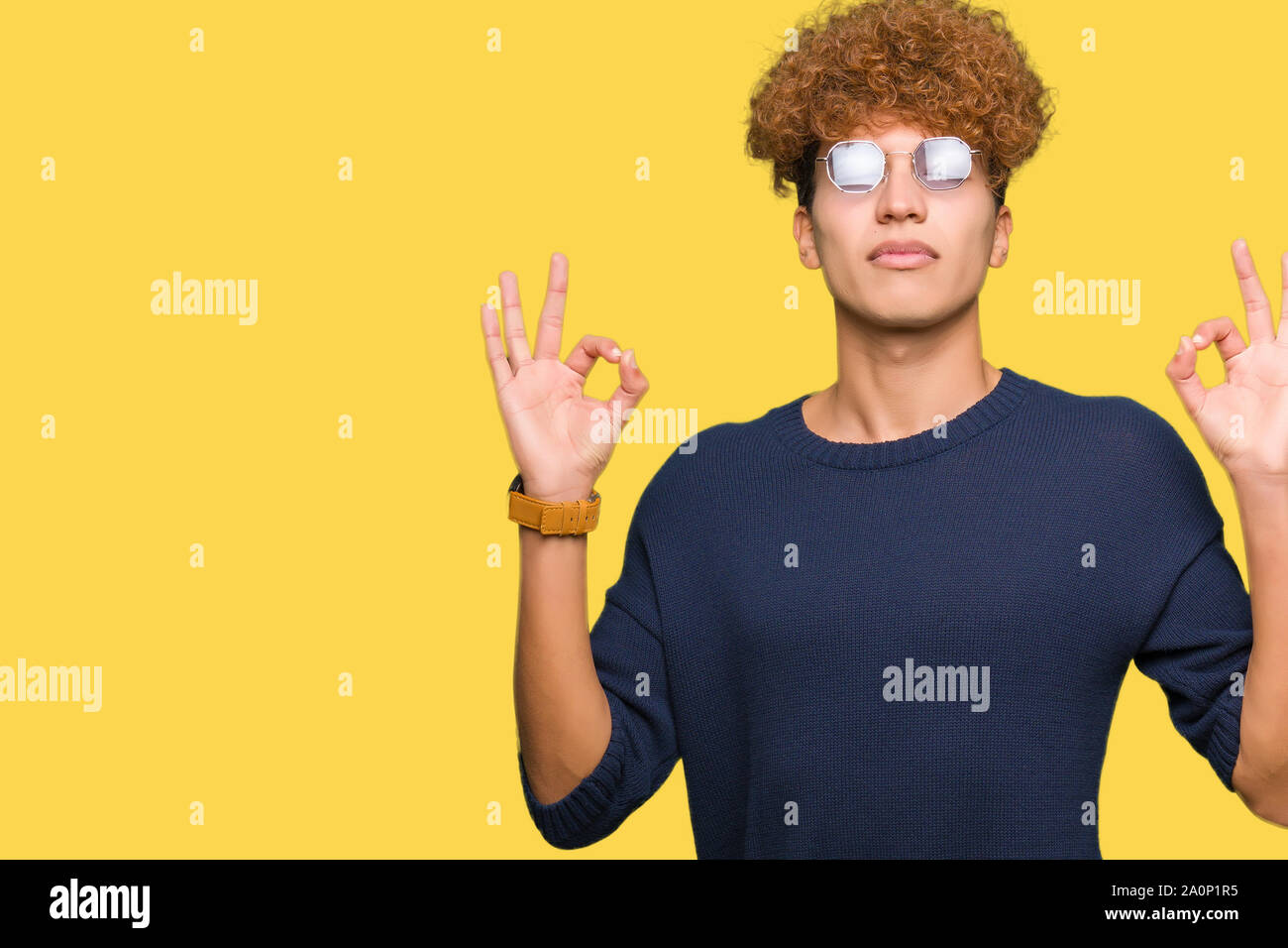 Young handsome man with afro wearing glasses relax and smiling with ...