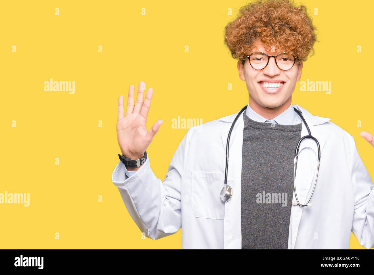 Young handsome doctor man wearing medical coat showing and pointing up ...