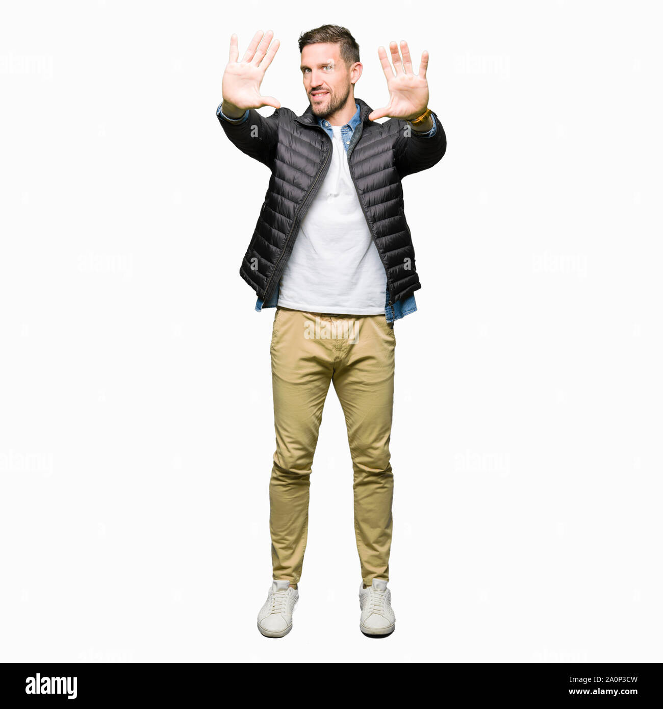 Handsome man wearing winter coat Smiling doing frame using hands palms ...