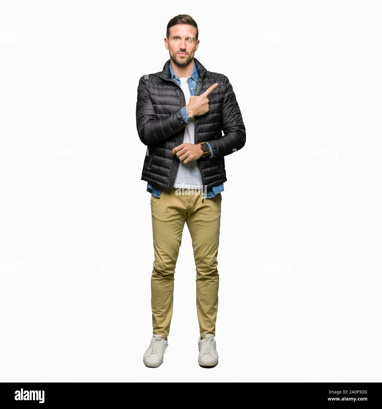 Handsome man wearing winter coat Pointing with hand finger to the side ...