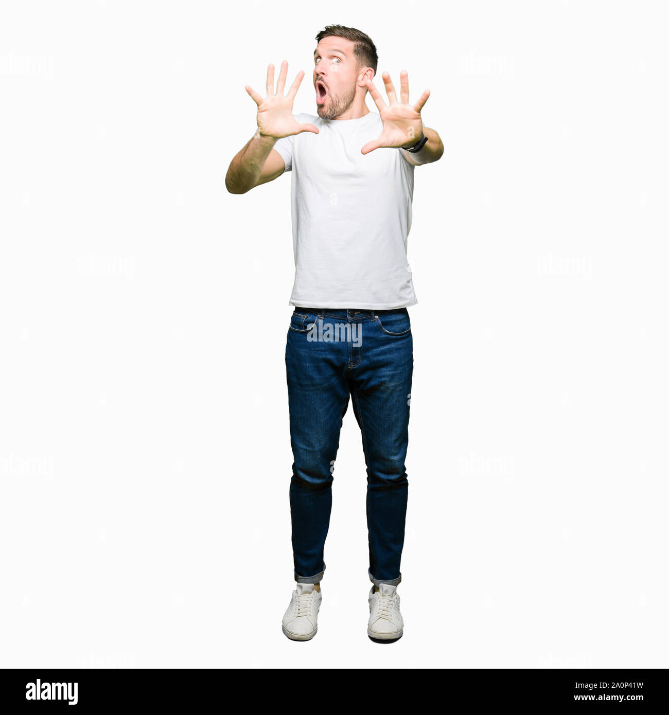Handsome man wearing casual white t-shirt afraid and terrified with ...