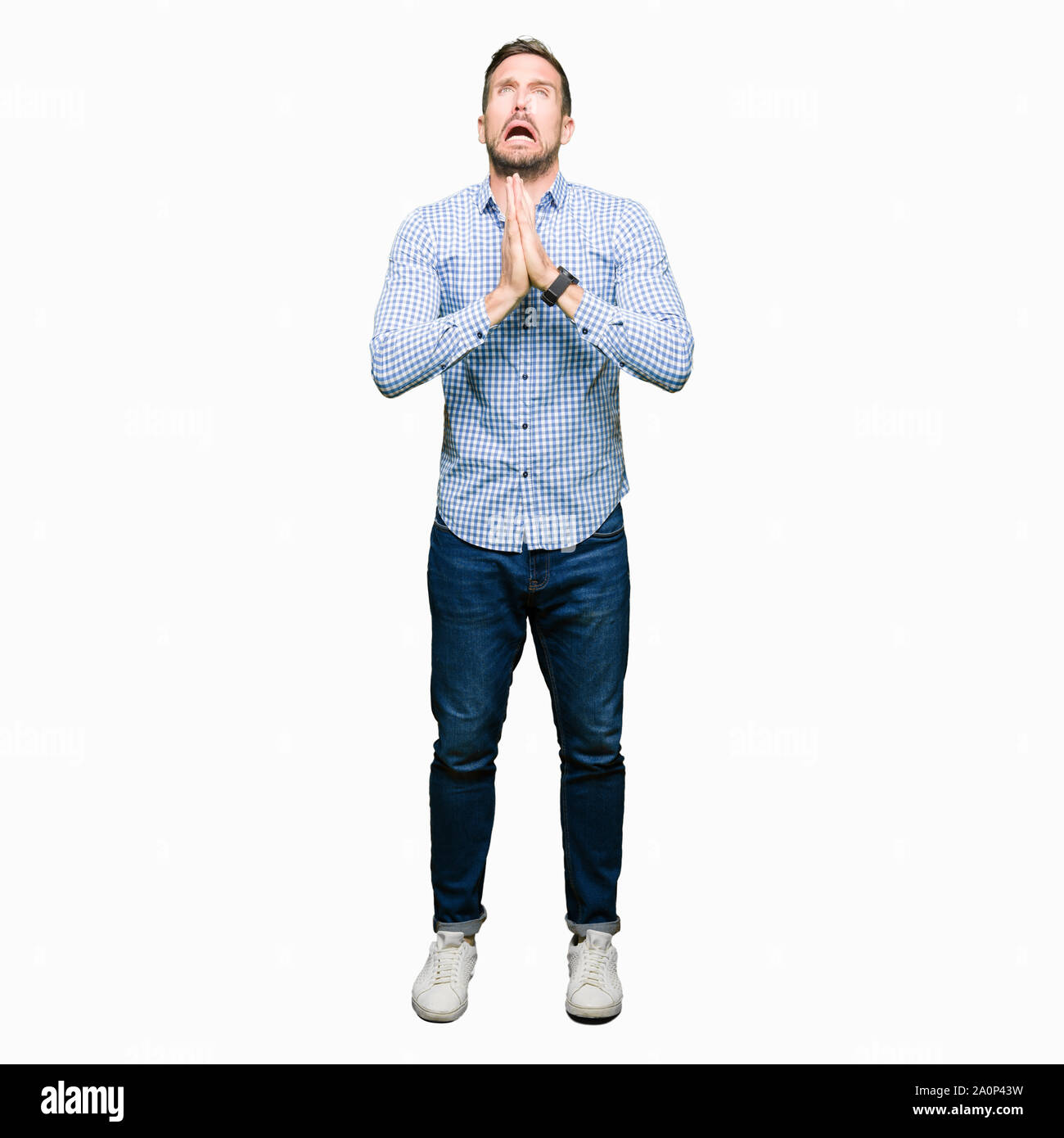 Handsome business man with blue eyes begging and praying with hands ...
