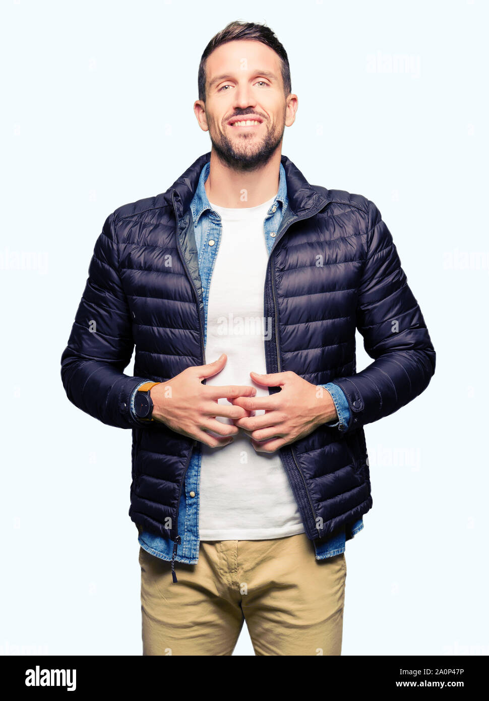 Handsome man wearing winter coat Hands together and fingers crossed ...
