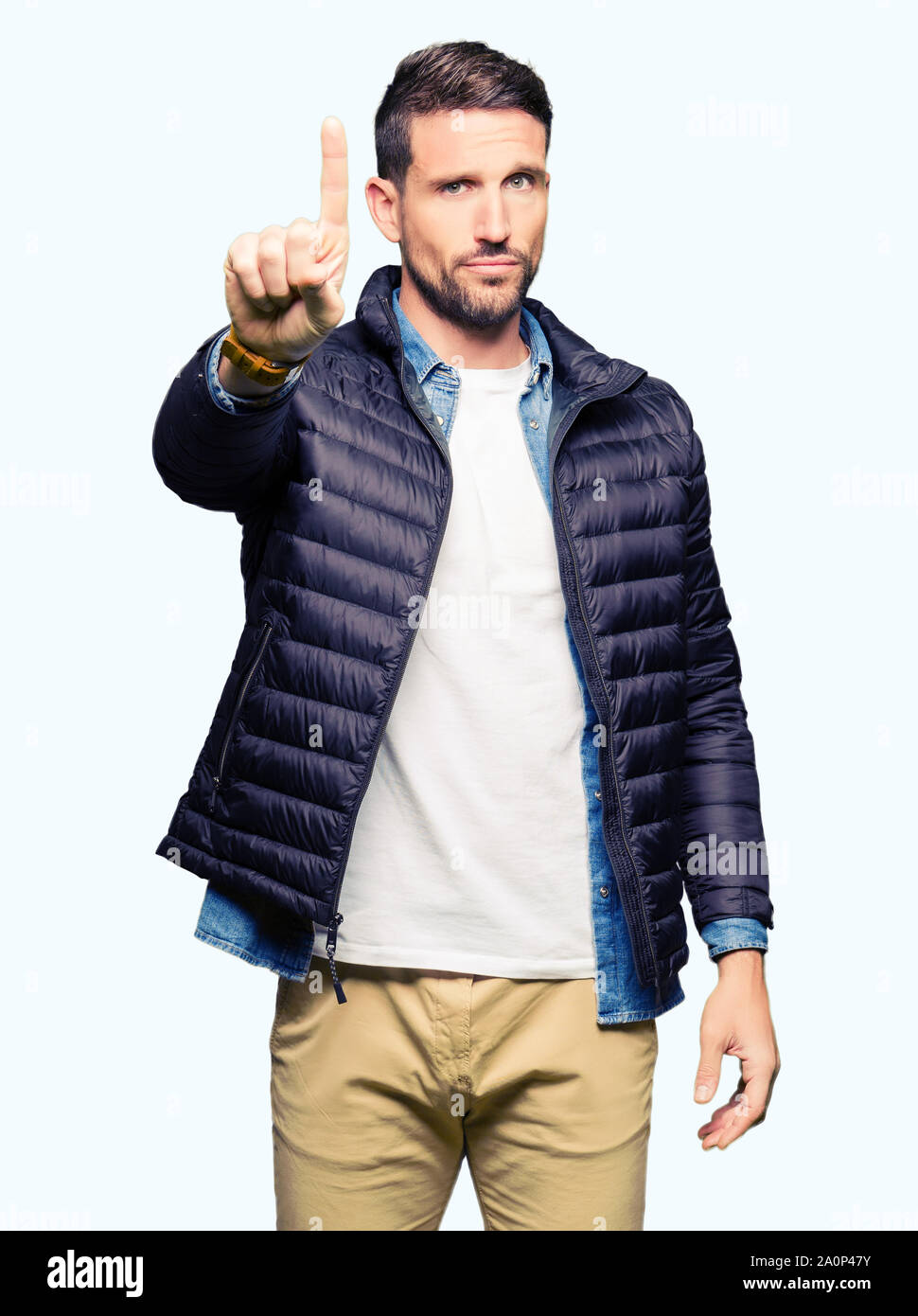 Handsome man wearing winter coat Pointing with finger up and angry ...