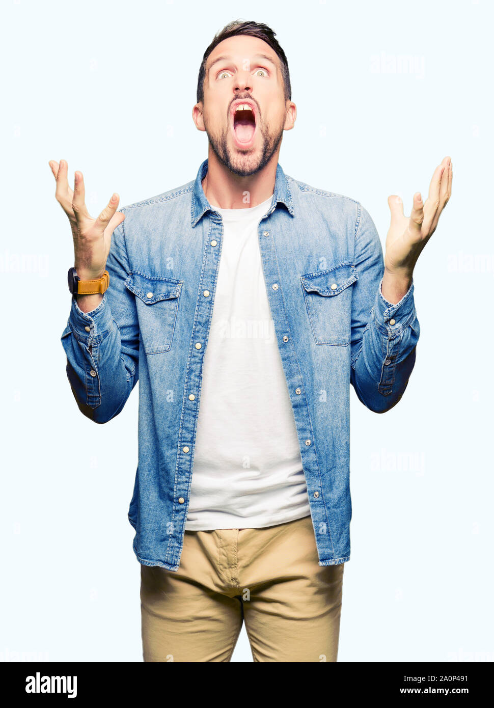 Handsome man with blue eyes and beard wearing denim jacket crazy and ...