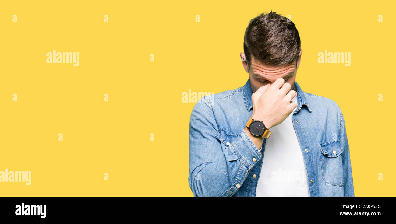 Handsome man with blue eyes and beard wearing denim jacket tired ...
