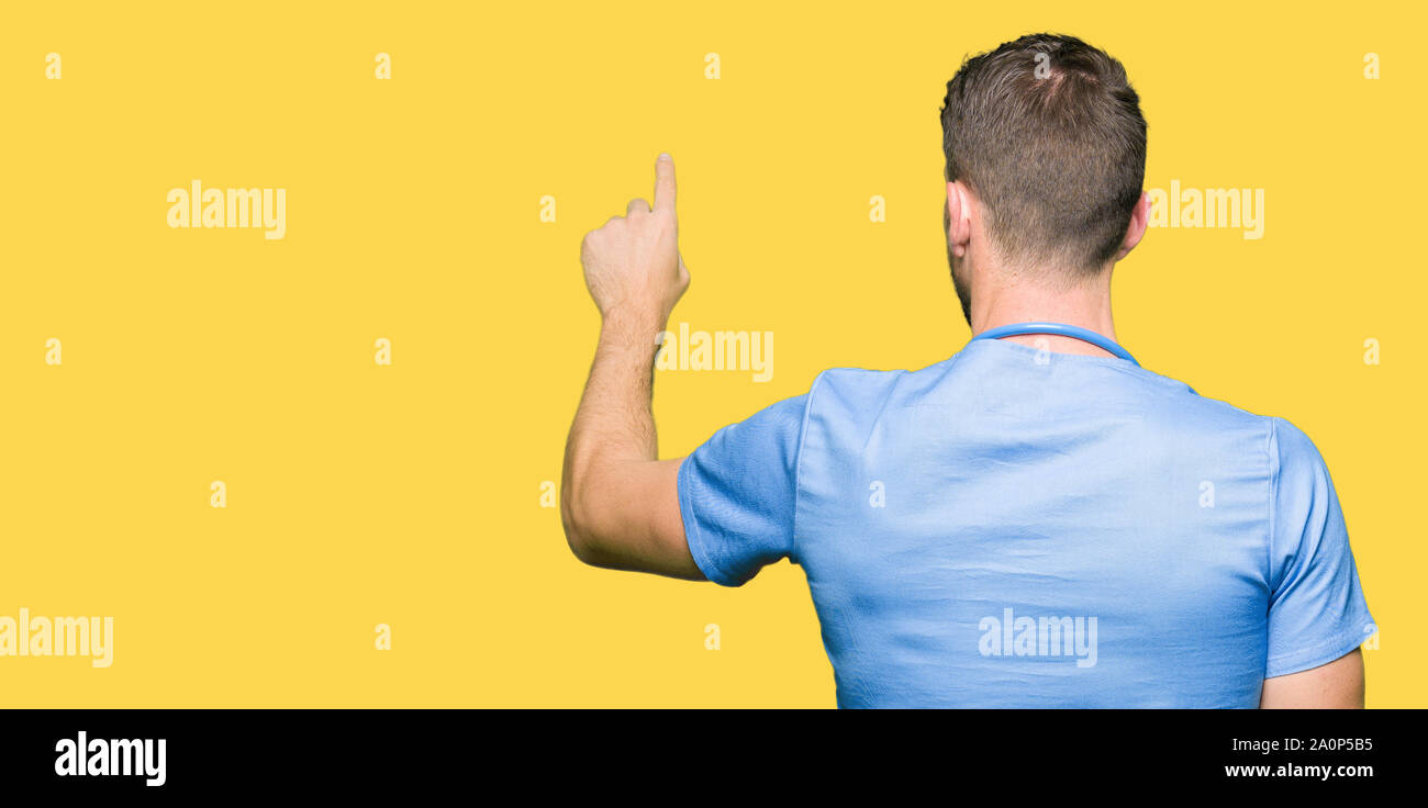 Handsome doctor man wearing medical uniform over isolated background ...