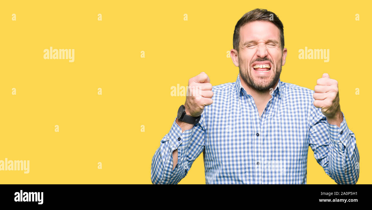 Handsome business man with blue eyes excited for success with arms ...