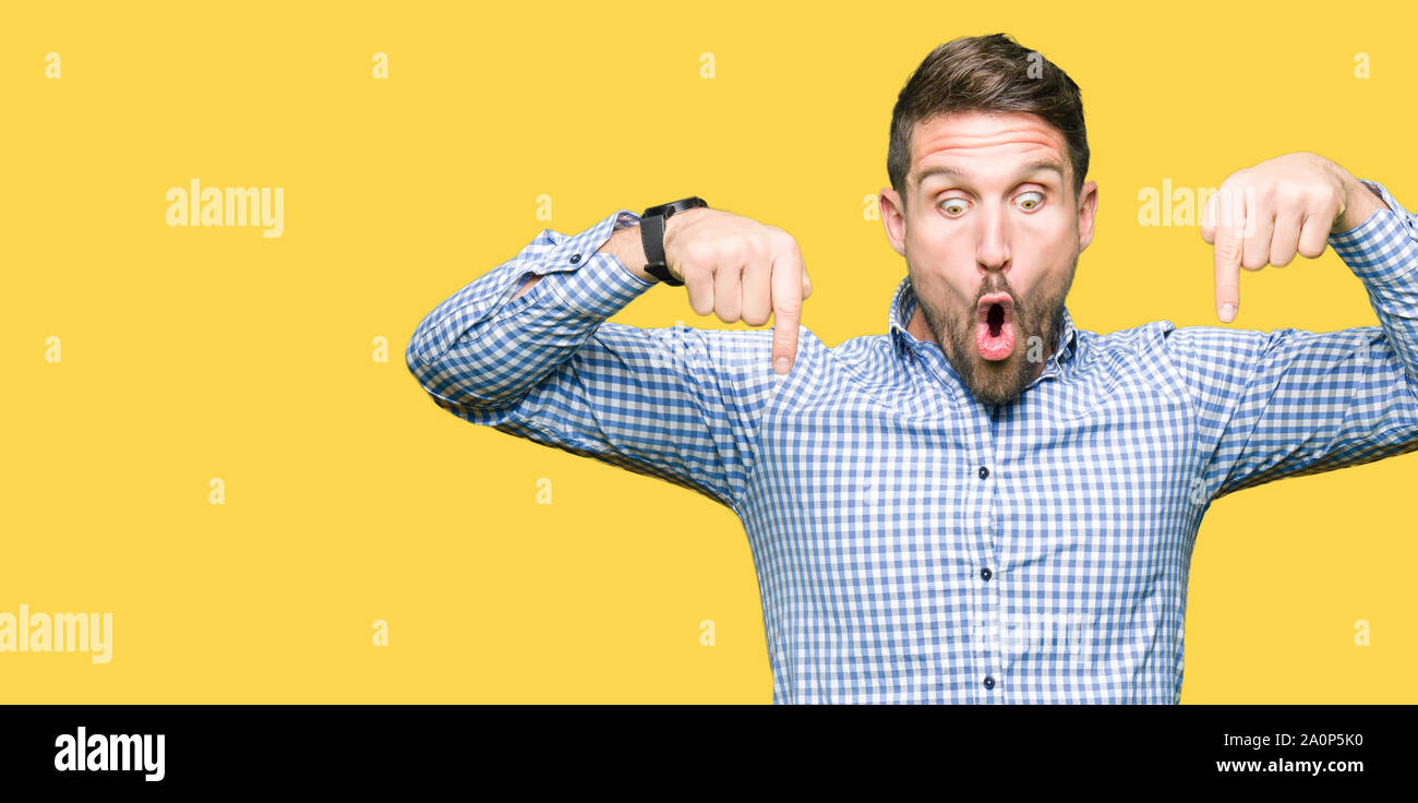 Handsome business man with blue eyes Pointing down with fingers showing ...