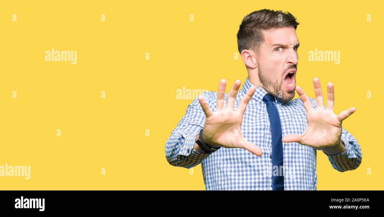 Handsome business man wearing tie afraid and terrified with fear ...