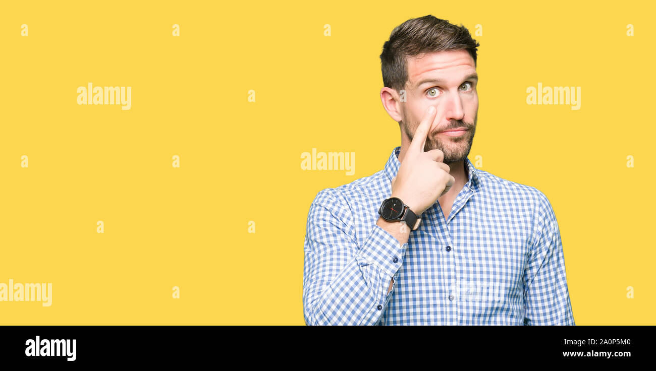 Handsome business man with blue eyes Pointing to the eye watching you ...