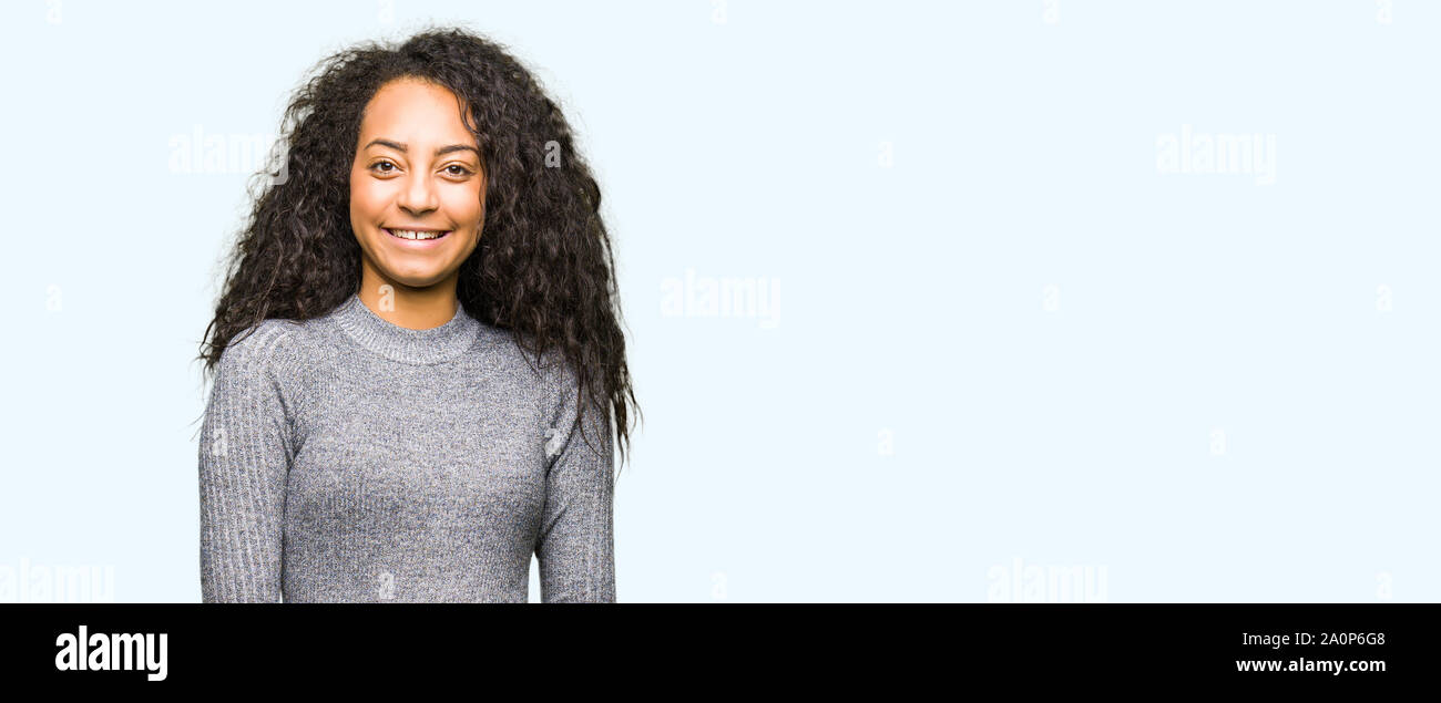 Young beautiful girl with curly hair with a happy and cool smile on ...