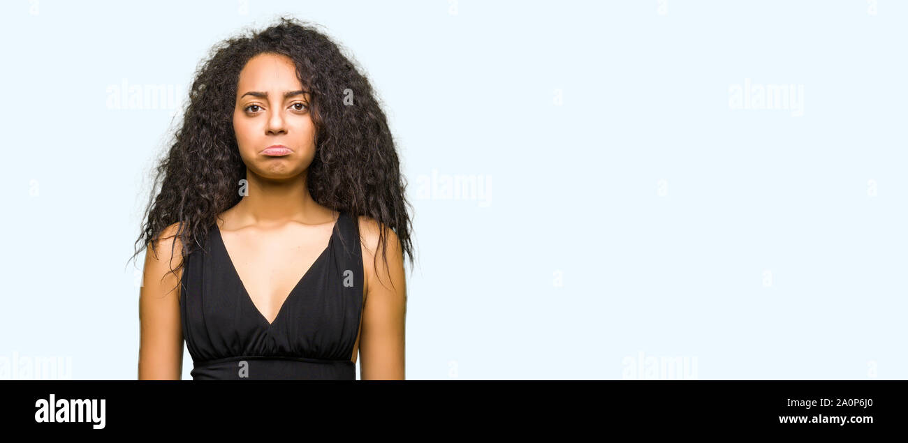 Young beautiful girl with curly hair wearing fashion skirt depressed ...