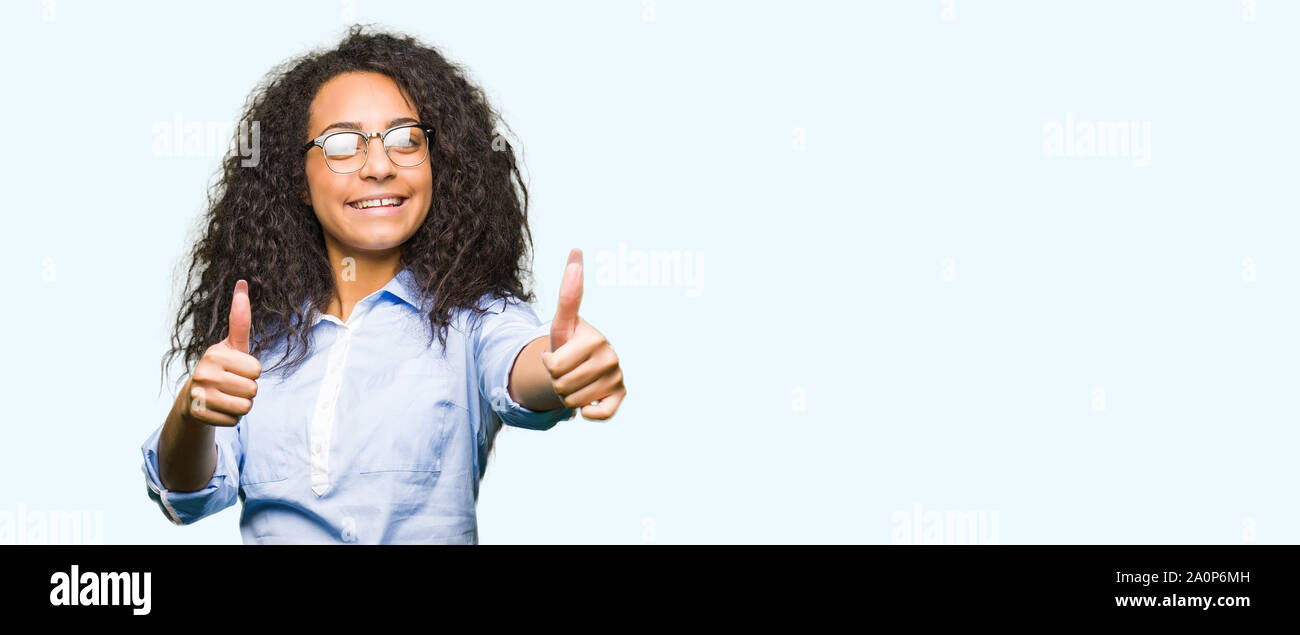 Young beautiful business girl with curly hair wearing glasses approving ...