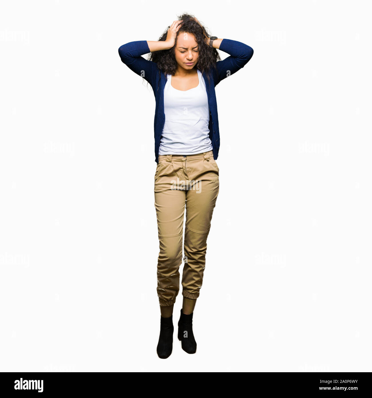 Young beautiful girl with curly hair suffering from headache desperate ...