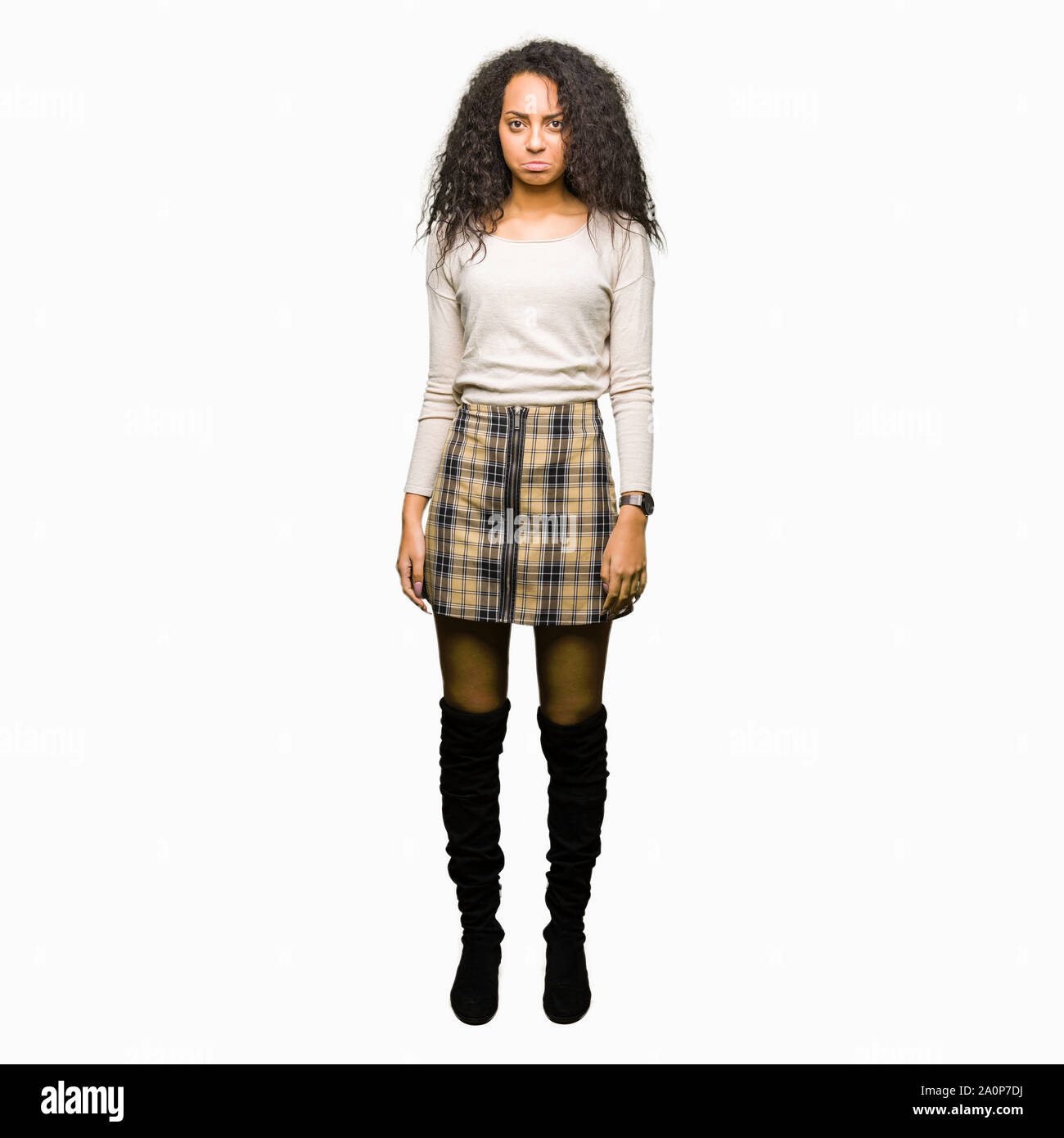 Young beautiful girl with curly hair wearing casual sweater depressed ...