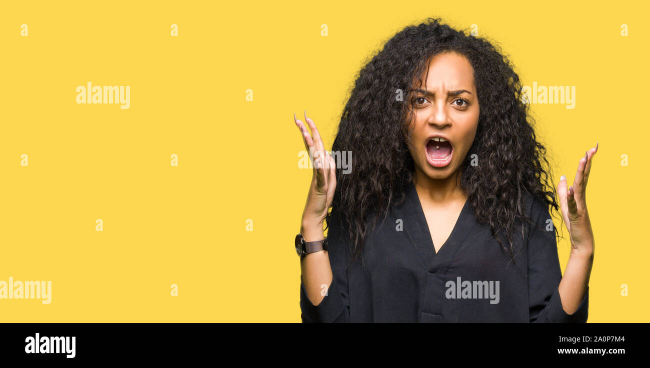 Young beautiful girl with curly hair wearing elegant dress crazy and ...