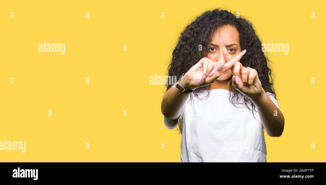 Young beautiful girl with curly hair wearing casual white t-shirt ...