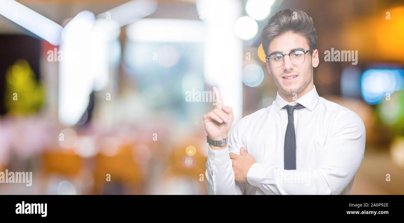 Young business man wearing glasses over isolated background with a big ...