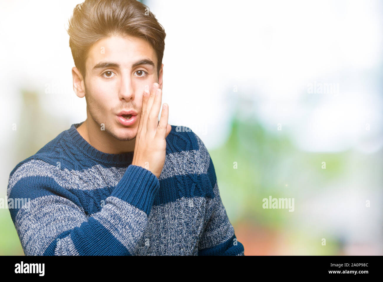 Young handsome man over isolated background hand on mouth telling ...