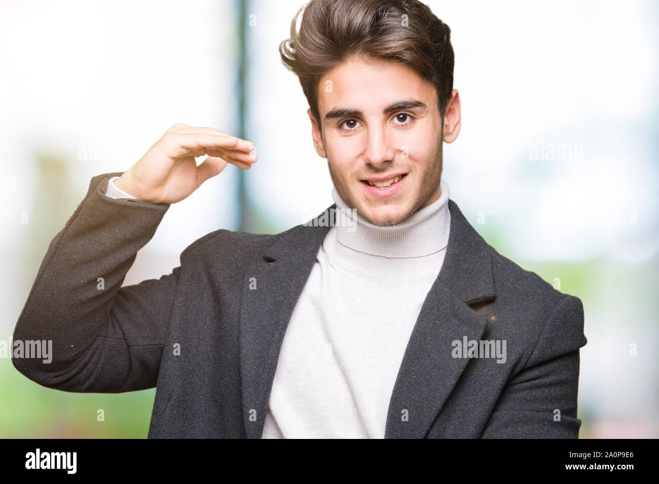 Young elegant man wearing winter coat over isolated background ...