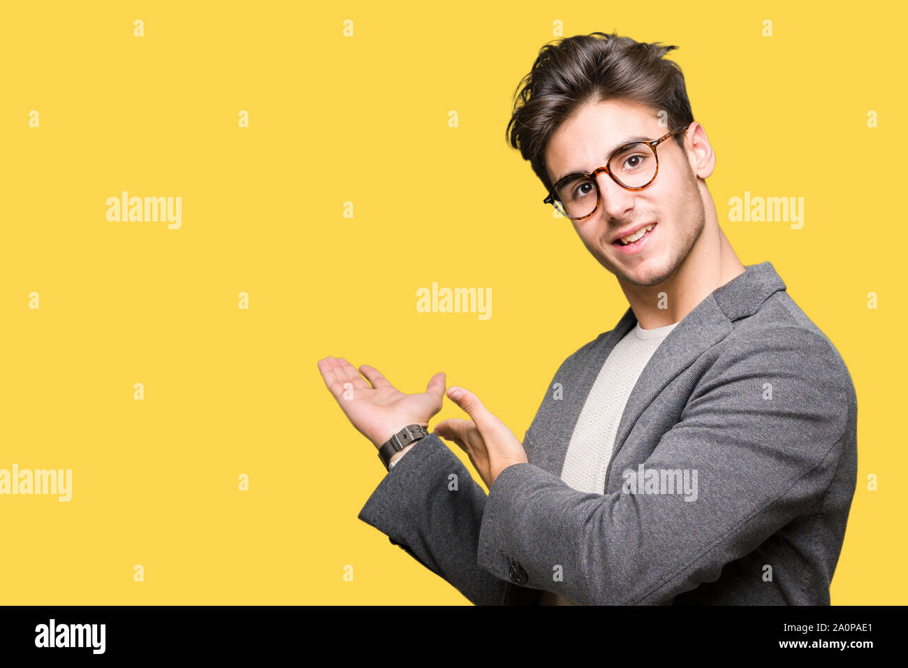 Young business man wearing glasses over isolated background Inviting to ...