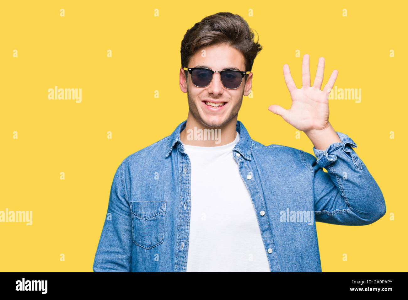 Young handsome man wearing sunglasses over isolated background showing ...