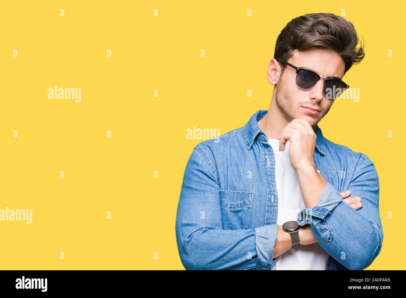 Young handsome man wearing sunglasses over isolated background with ...