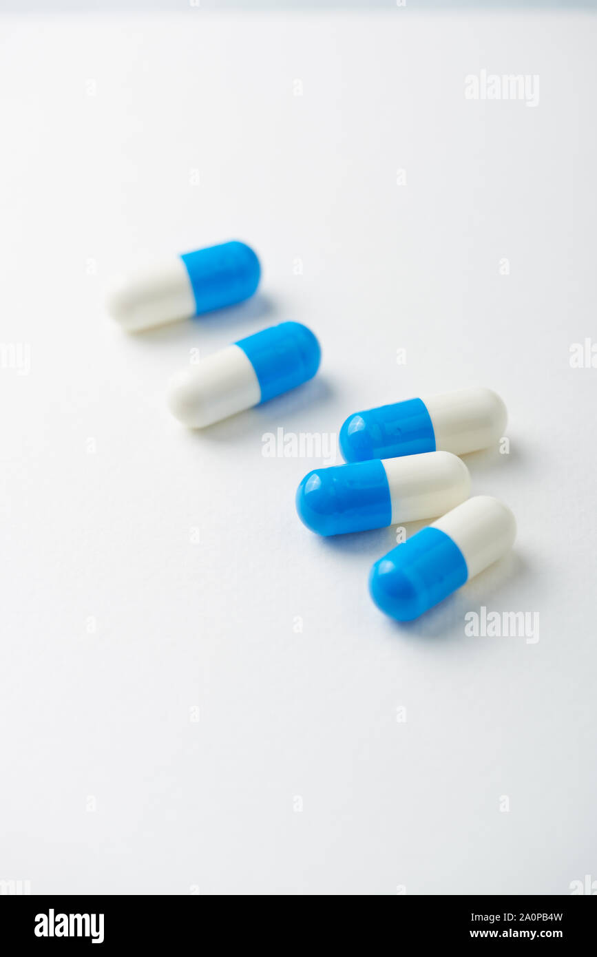 Creatine capsules. Sports supplements on bright paper background. Close ...