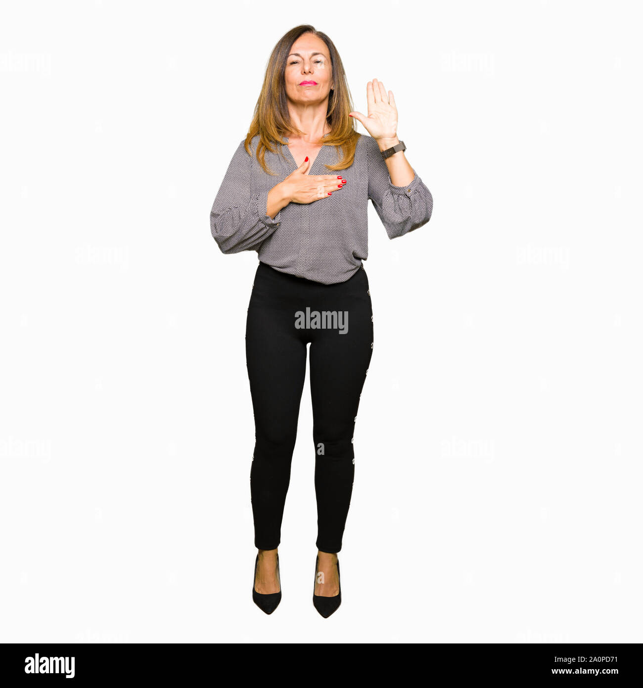 Beautiful middle age business woman Swearing with hand on chest and ...