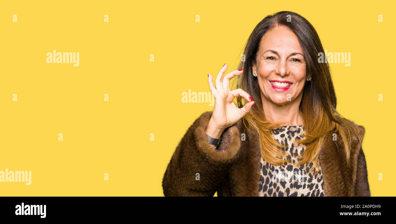 Beautiful middle age elegant woman wearing mink coat smiling positive ...