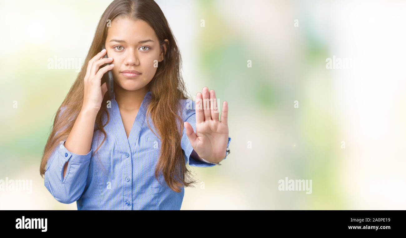 Young beautiful brunette business woman talking on smartphone over ...