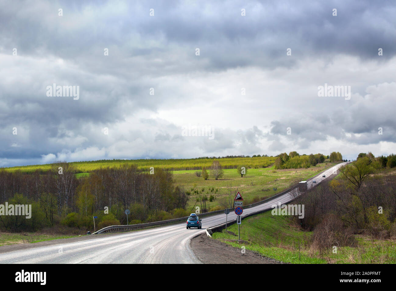 Road goes far away into the distance, horizon, few cars, green field ...