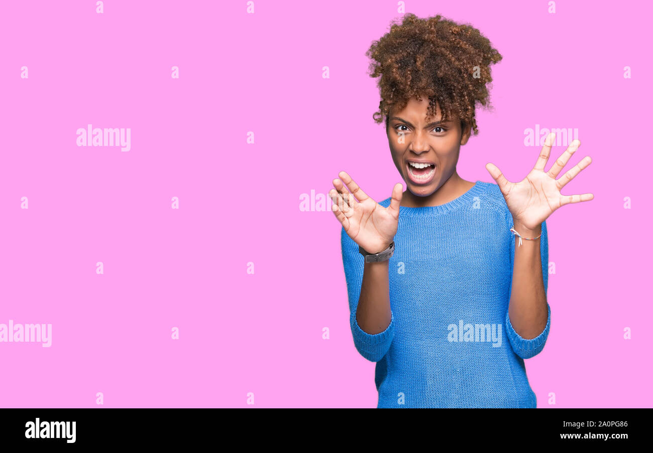 Beautiful young african american woman over isolated background afraid ...