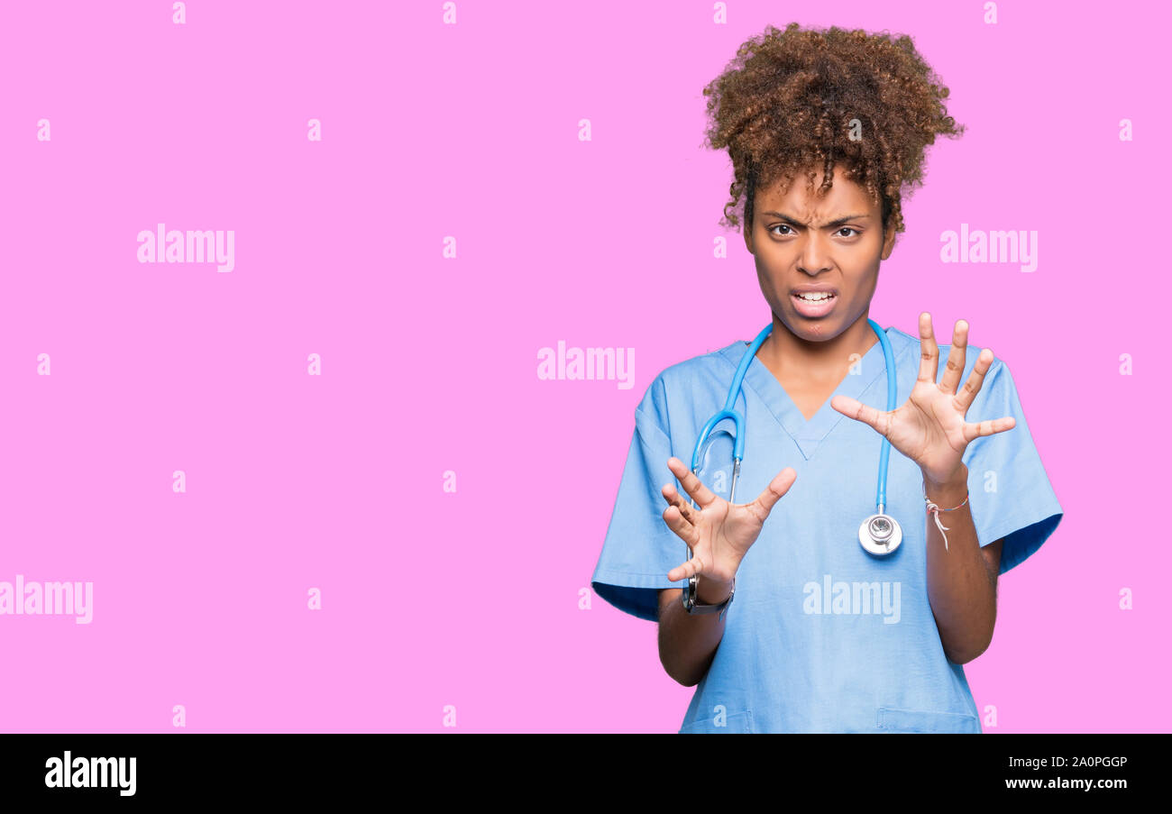 Young african american doctor woman over isolated background afraid and ...