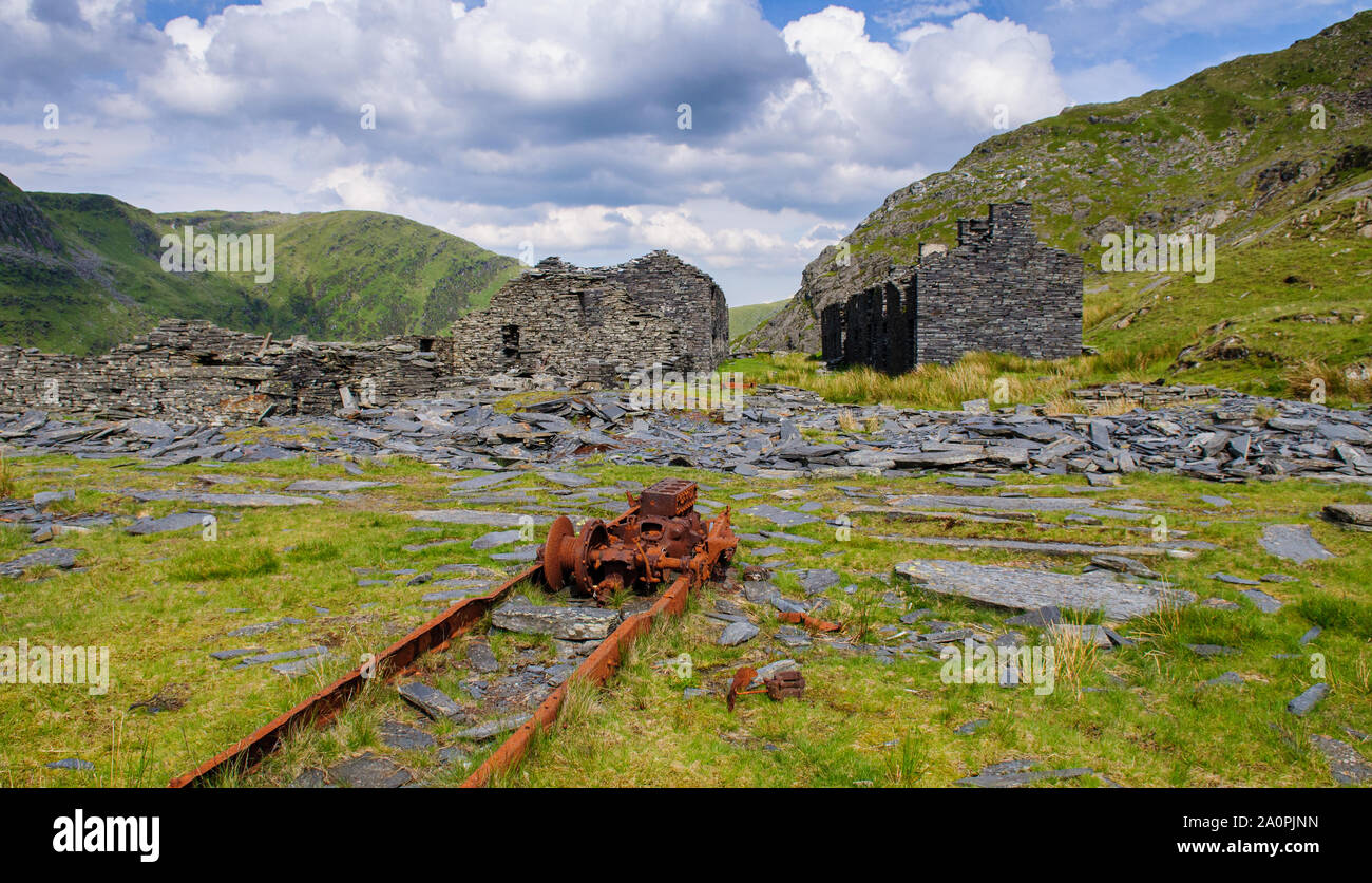 Abandoned and derelict slate mining buildings stand amidst scree tips ...