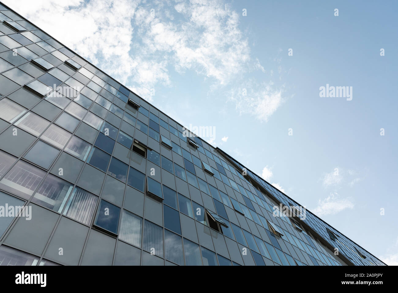 Glass building facade with several open windows on it Stock Photo - Alamy
