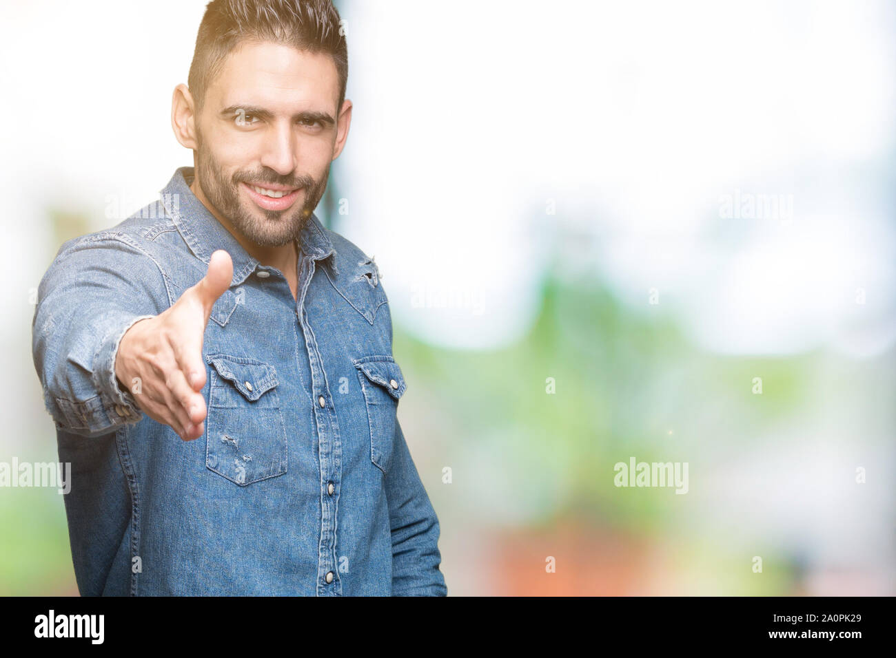 Young handsome man over isolated background smiling friendly offering ...