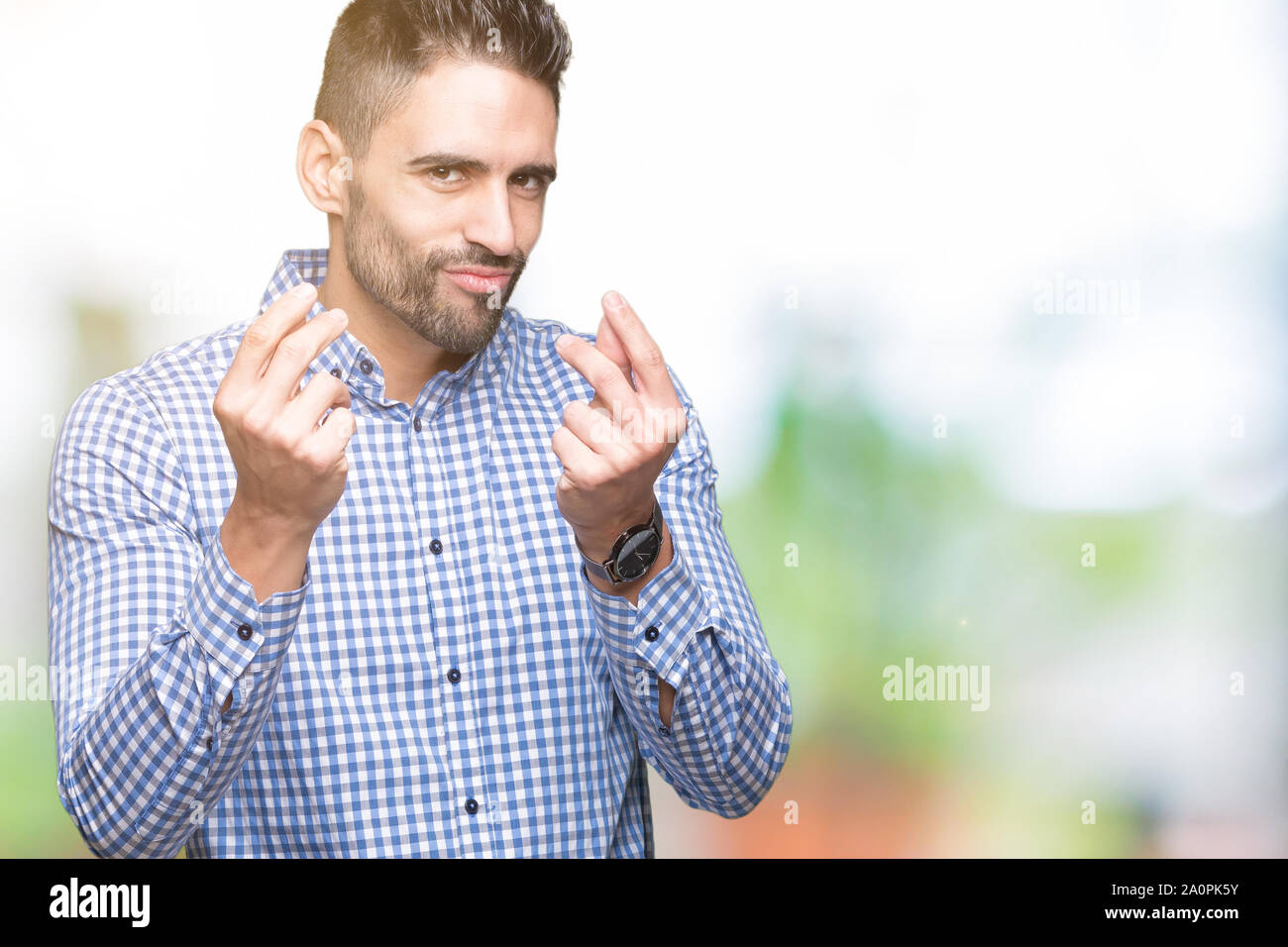 Young handsome man over isolated background Doing money gesture with ...