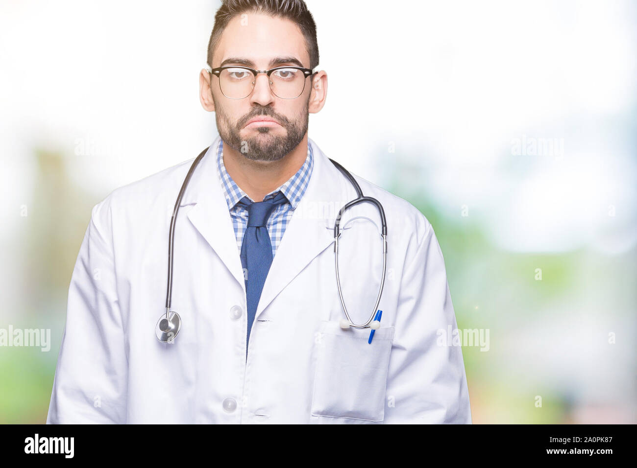 Handsome young doctor man over isolated background depressed and worry ...
